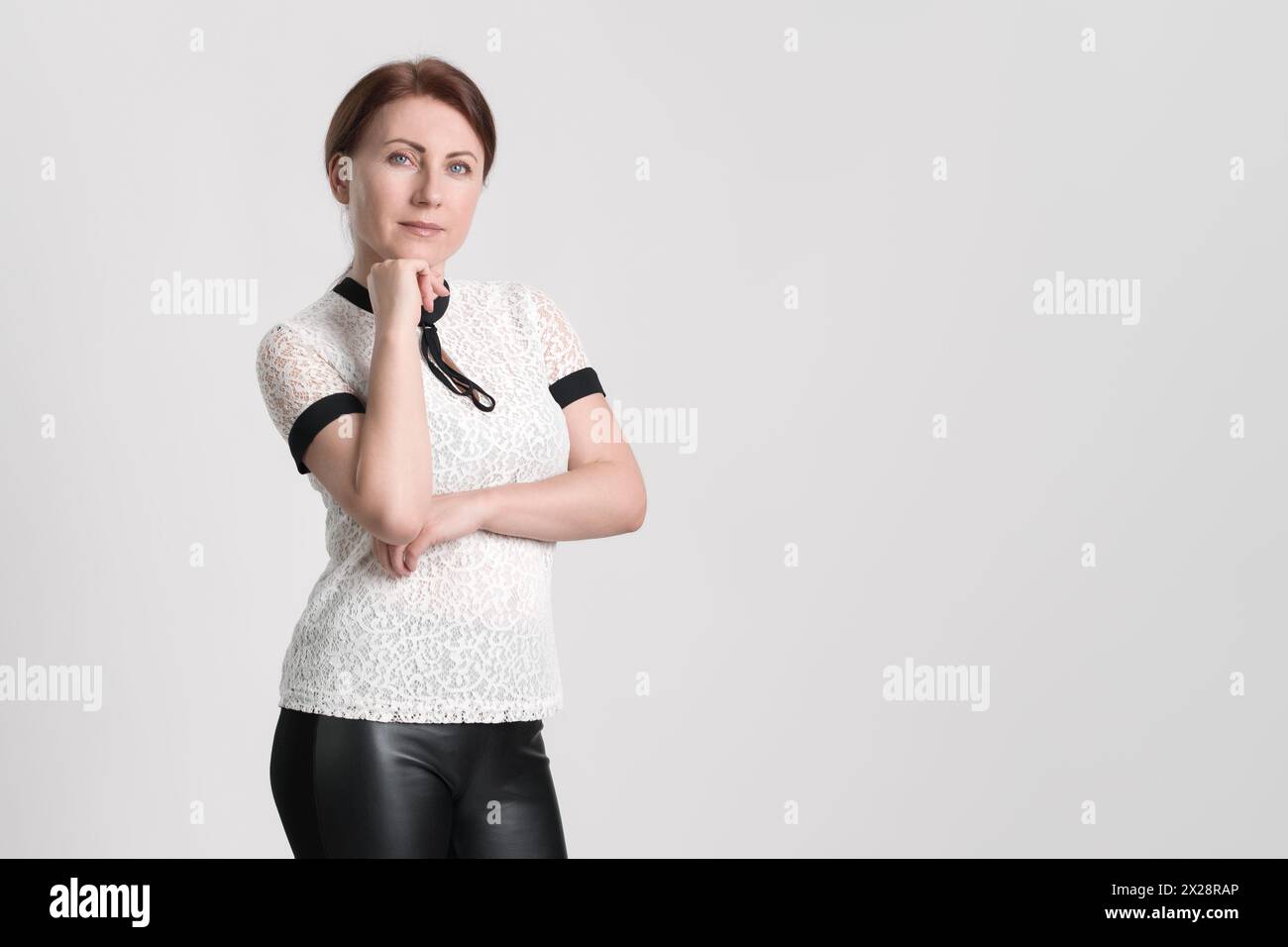 Formal portrait of Caucasian business woman looking at camera with one ...
