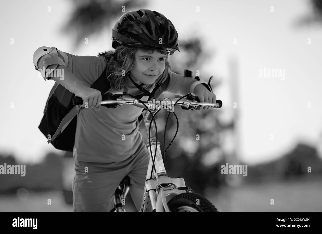 Sporty kid riding bike on a park. Child in safety helmet riding bicycle ...