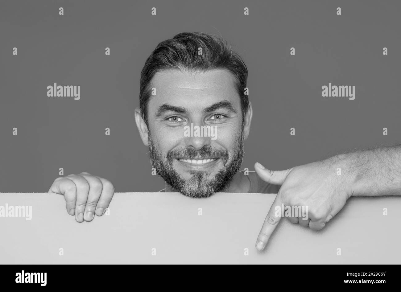 Guy with blank banner ad, isolated on studio background. Man holding ...