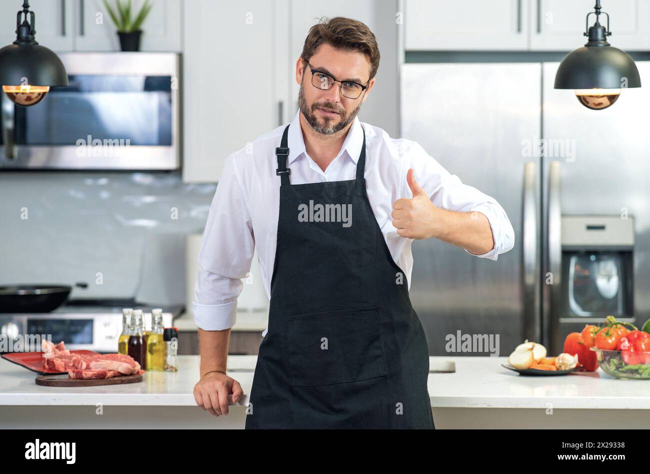 Handsome man chef in uniform cooking in the kitchen. Restaurant menu ...