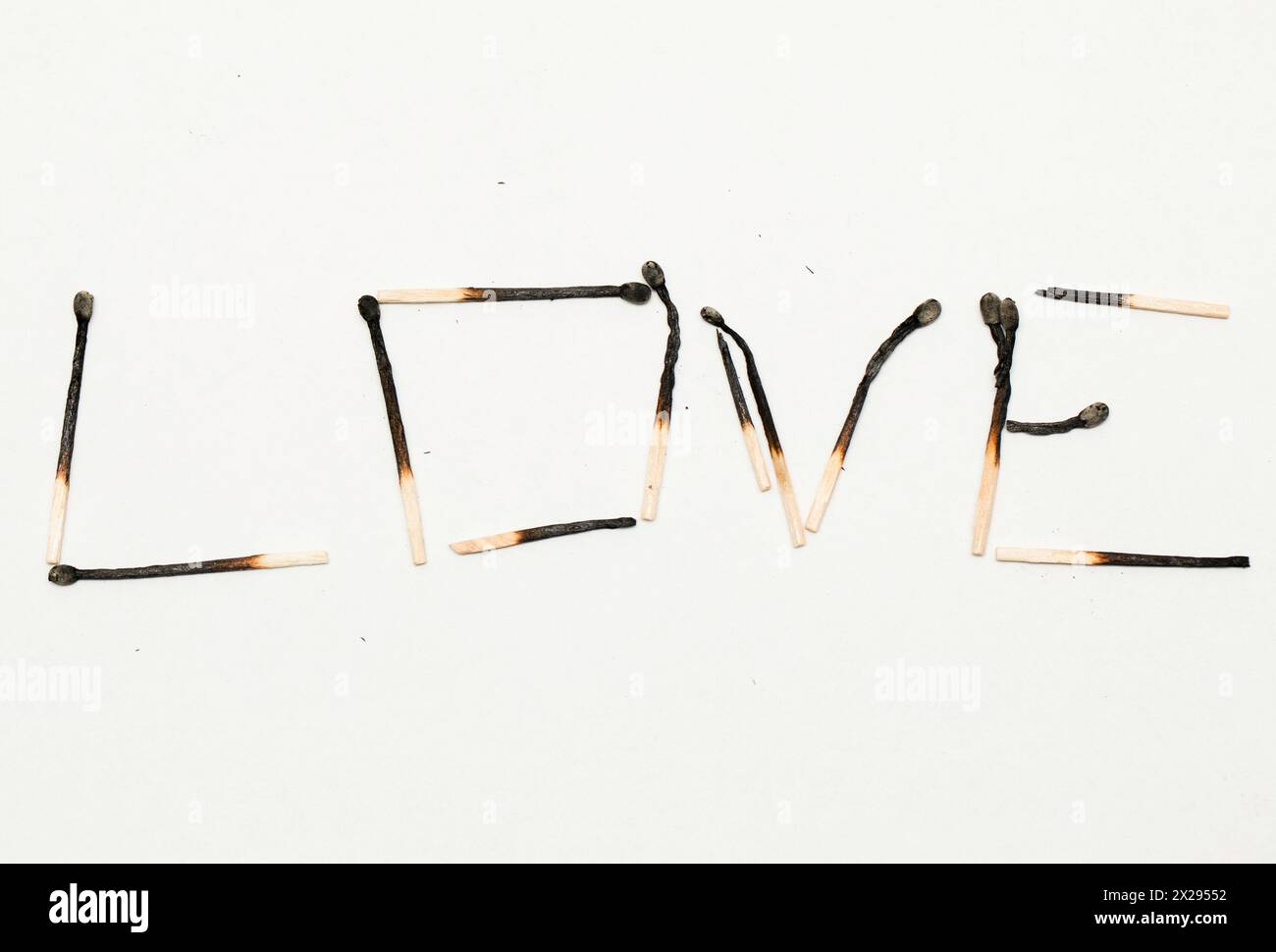 Love - an expression arranged from burnt matches on a white background ...
