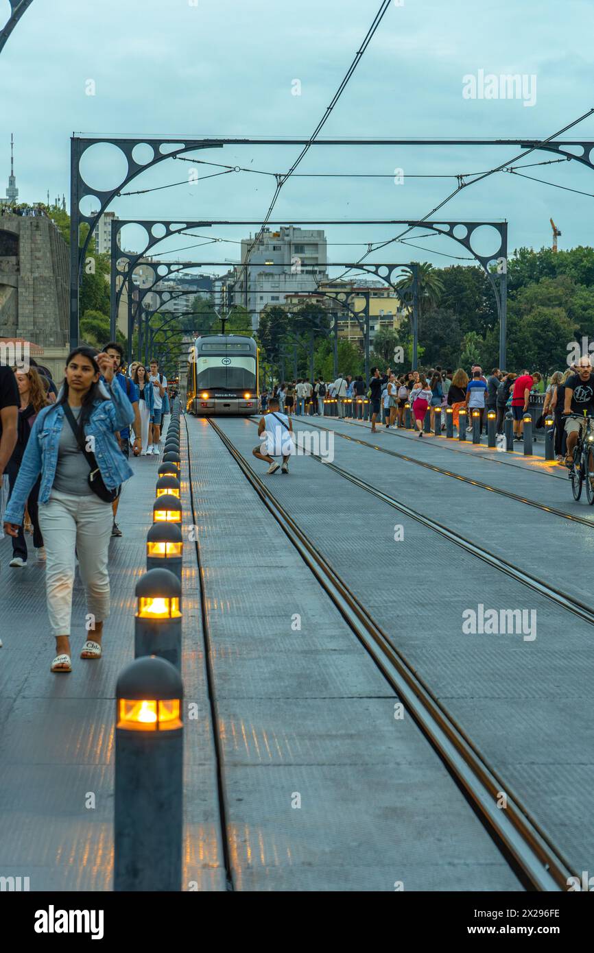 Tourist crouching taking a photo of an approaching train on the Porto ...