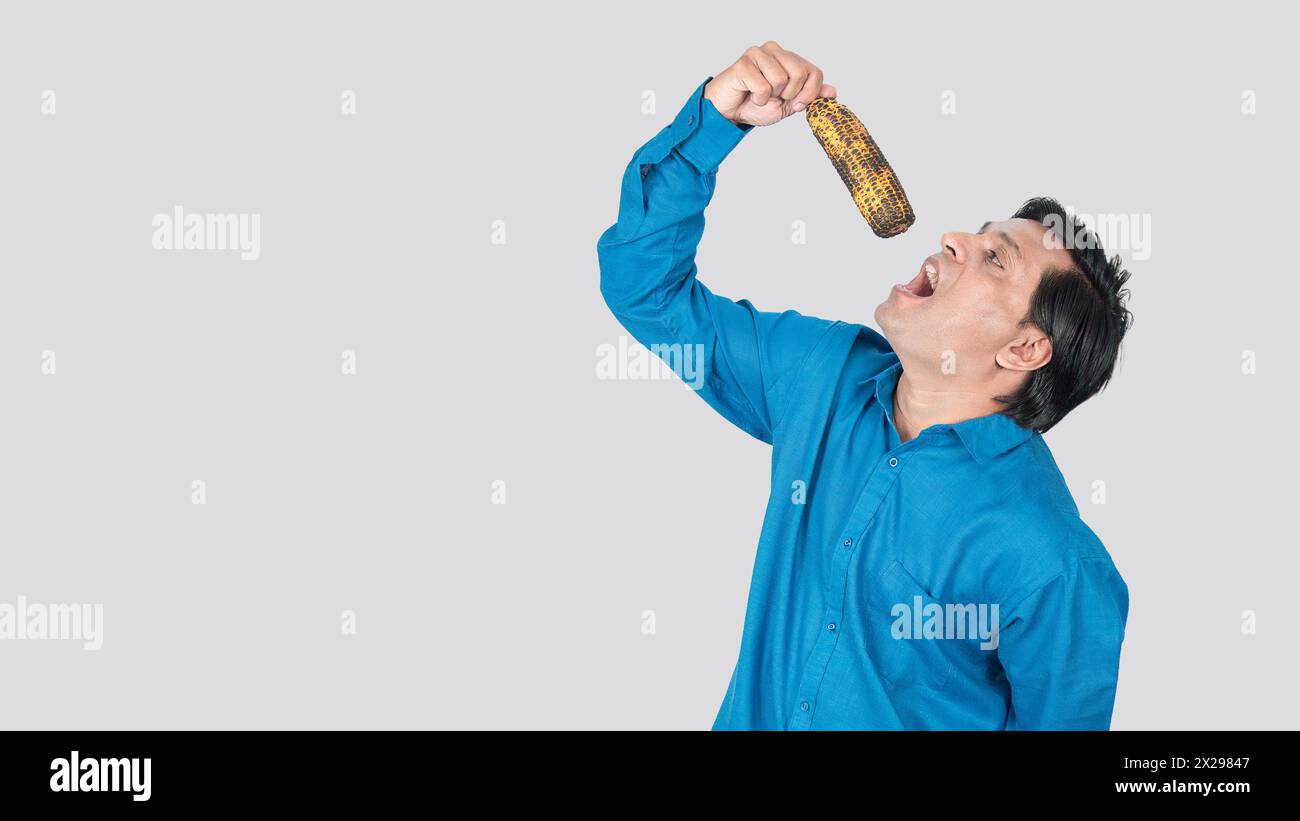a young boy try to eat corn cob like crazy way with his facial ...