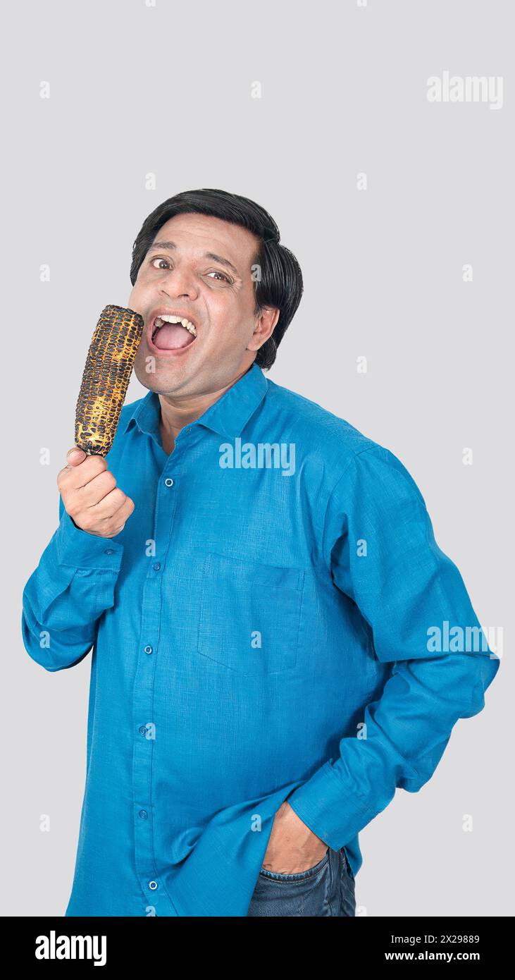 crazy facial expression of a young boy try to eat corn cob Stock Photo ...