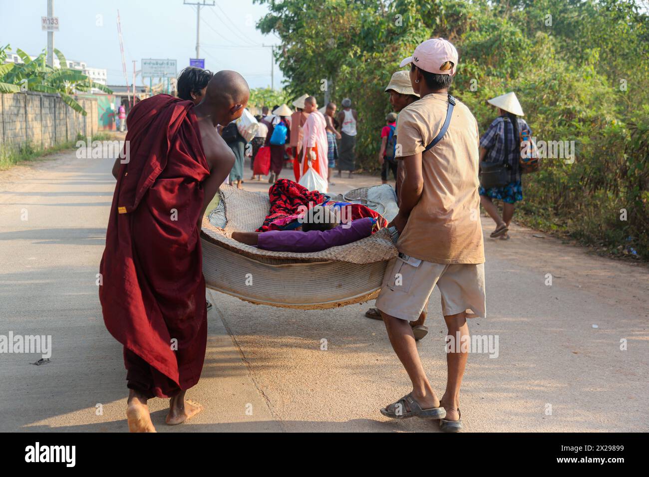 Men and novice are seen carrying the sick old man on the Thailand side after they flee from the ...