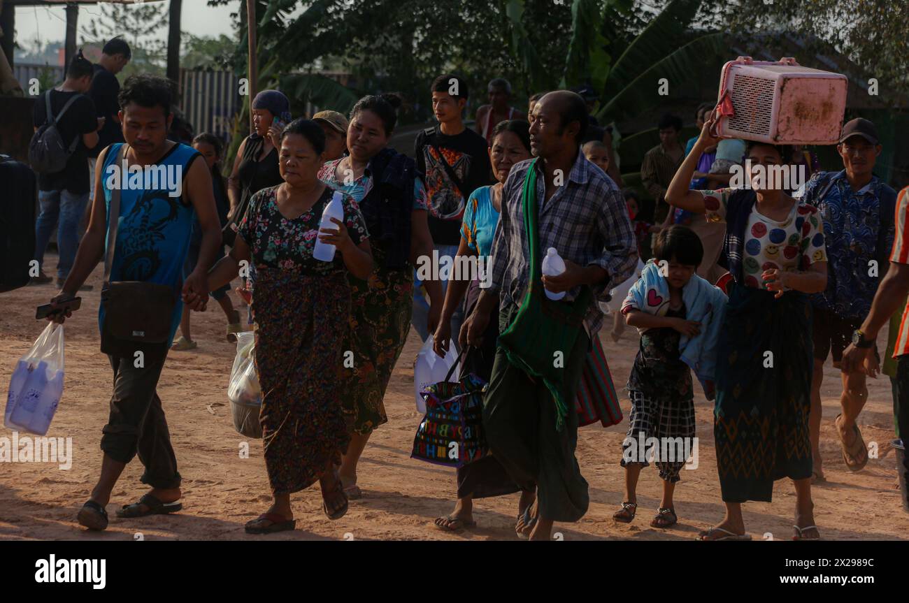 People carrying their bags arrive on the Thai side after they flee from ...