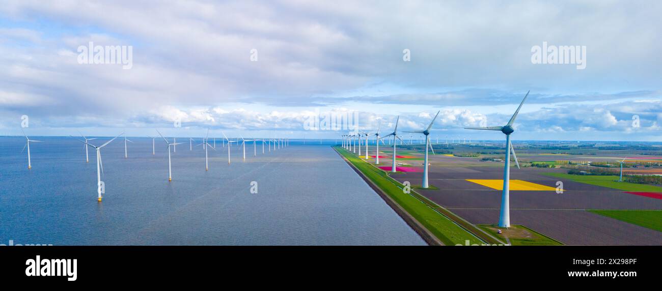 A serene scene unfolds as wind mills stand tall around a vast lake ...