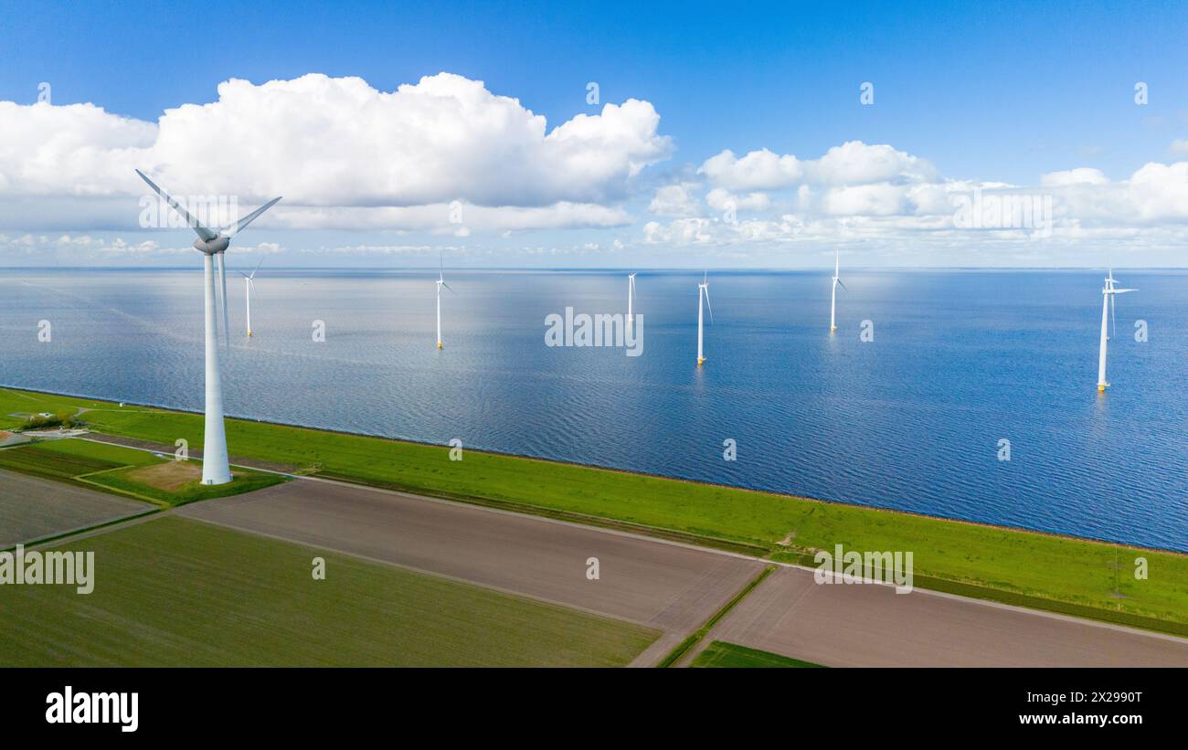 A wind farm filled with turbines in the ocean of the Netherlands ...