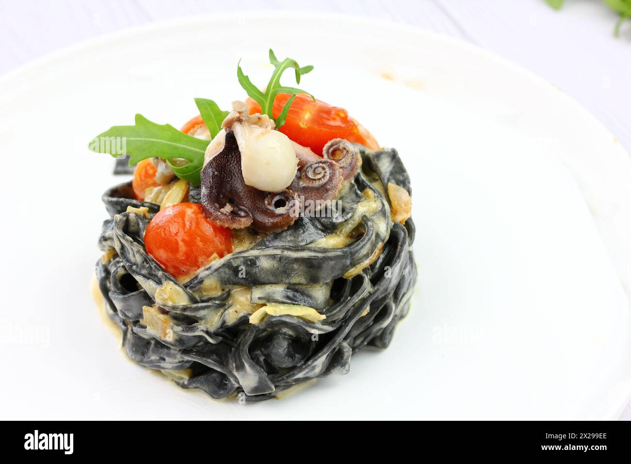 Black spaghetti. Black seafood pasta in white plate on black background ...
