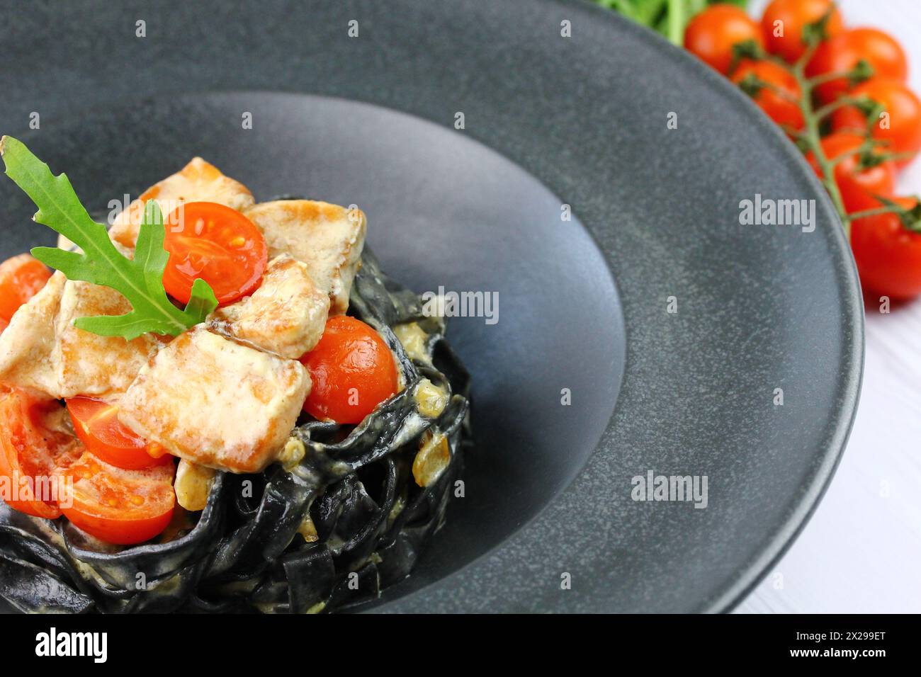 Black spaghetti. Black seafood pasta in white plate on black background ...