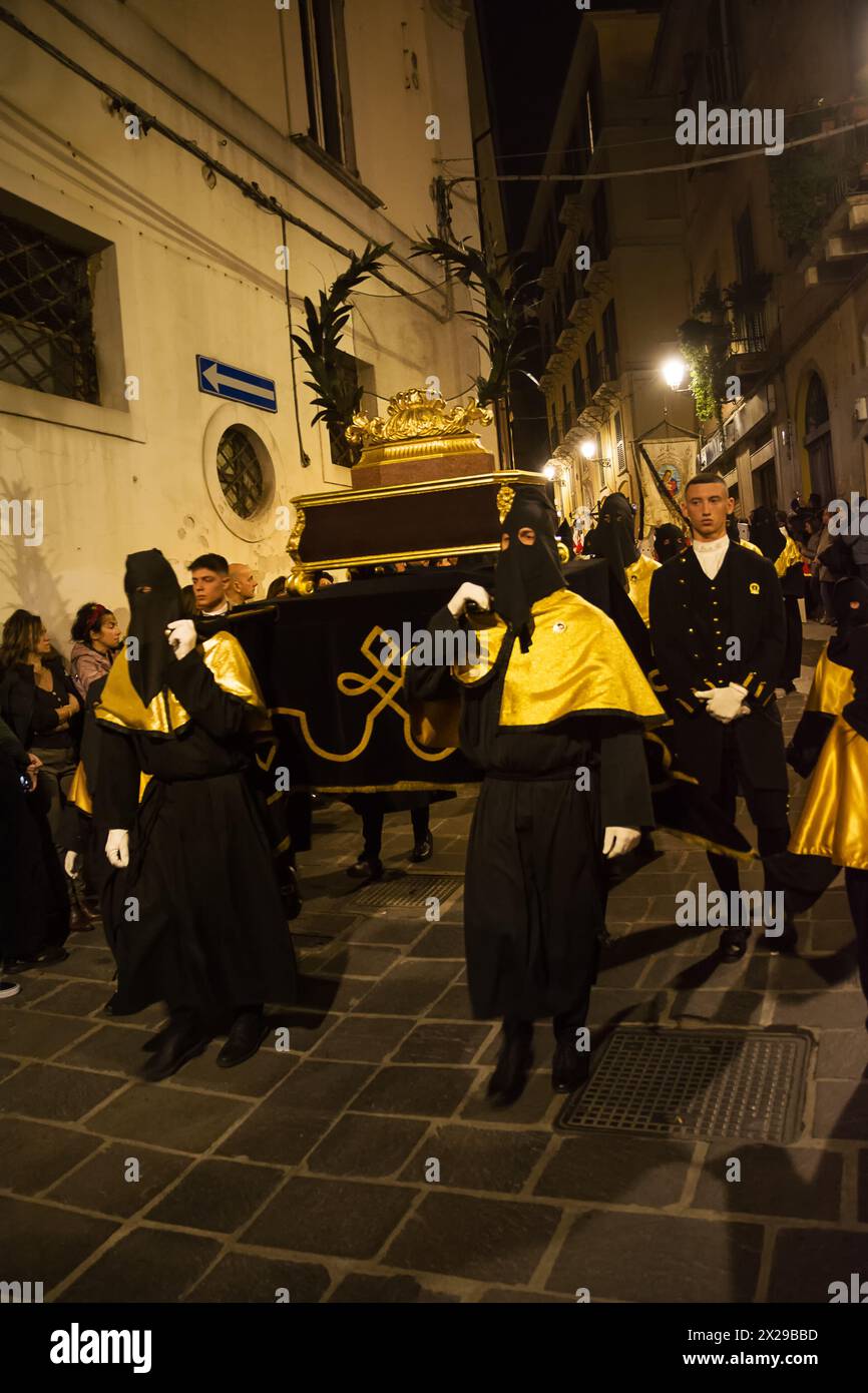 Chieti, Italy - March 29, 2024: Hooded faithful carry the symbols of ...