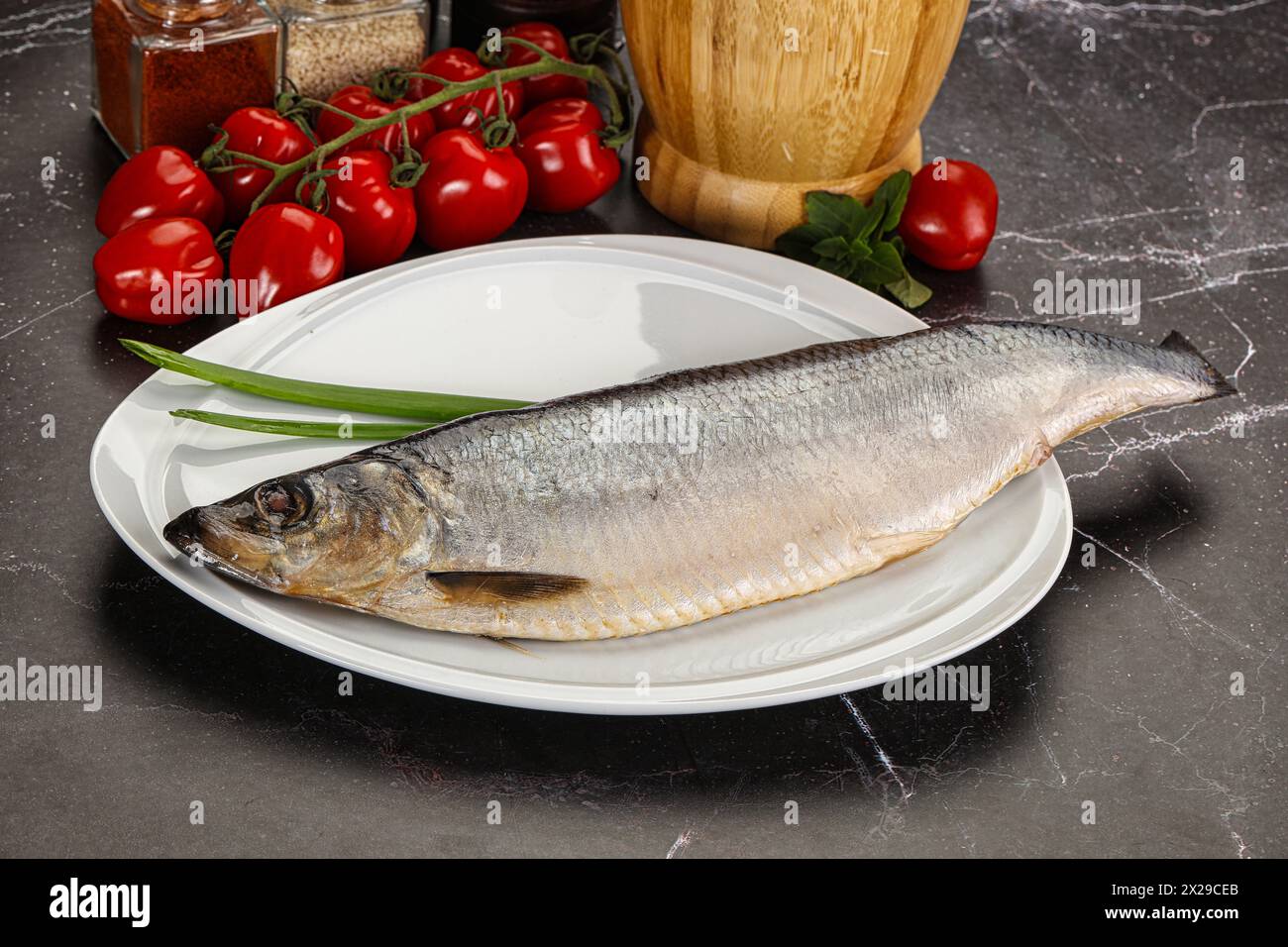 Whole raw salted herring fish in the plate Stock Photo - Alamy
