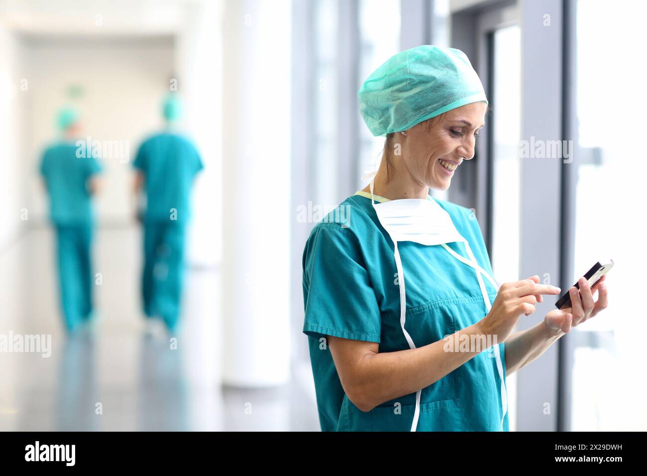 surgeon with smartphone in the operating room hallway, Onkologikoa ...