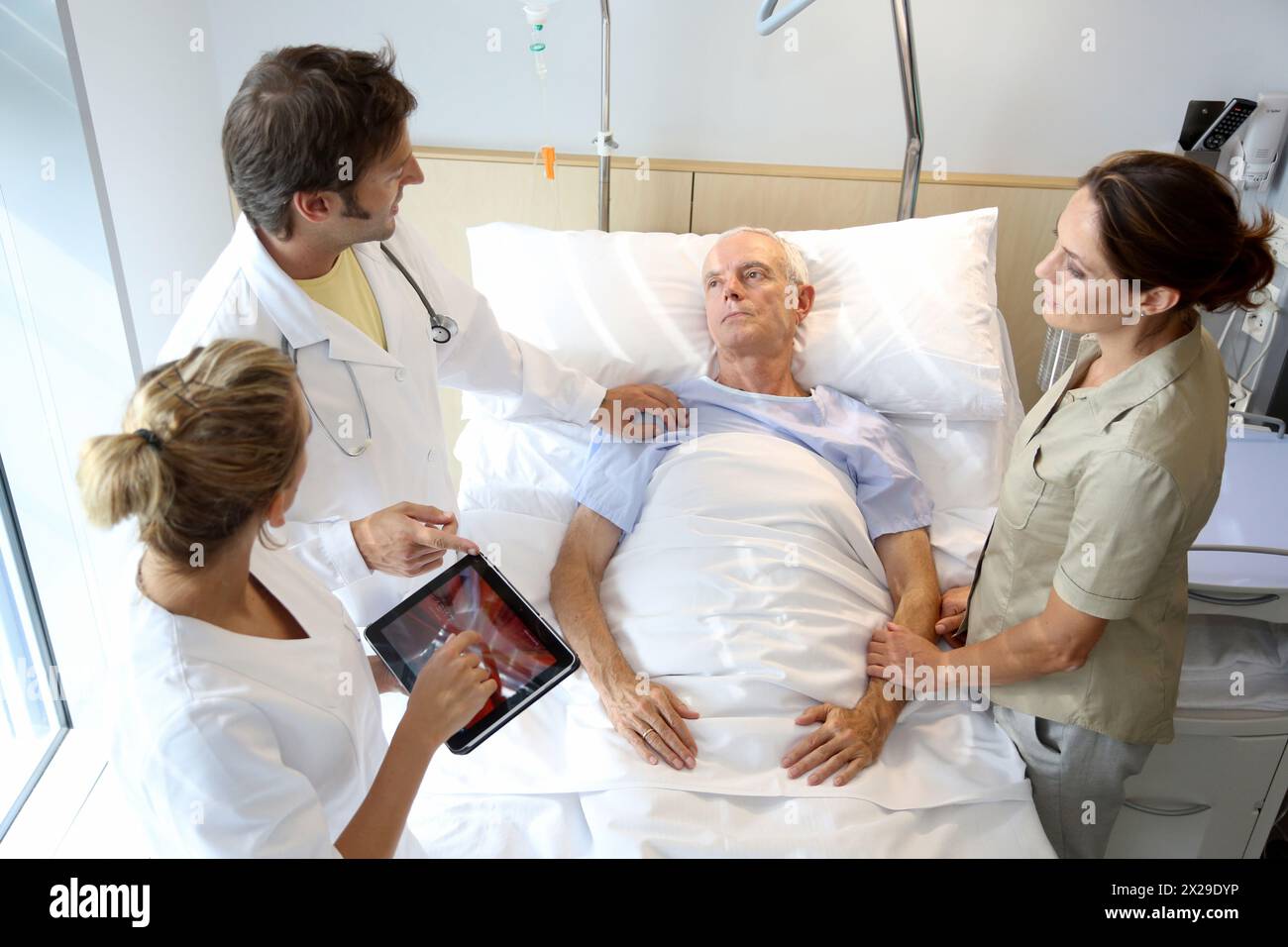 Nurse tablet attending patient hi-res stock photography and images - Alamy