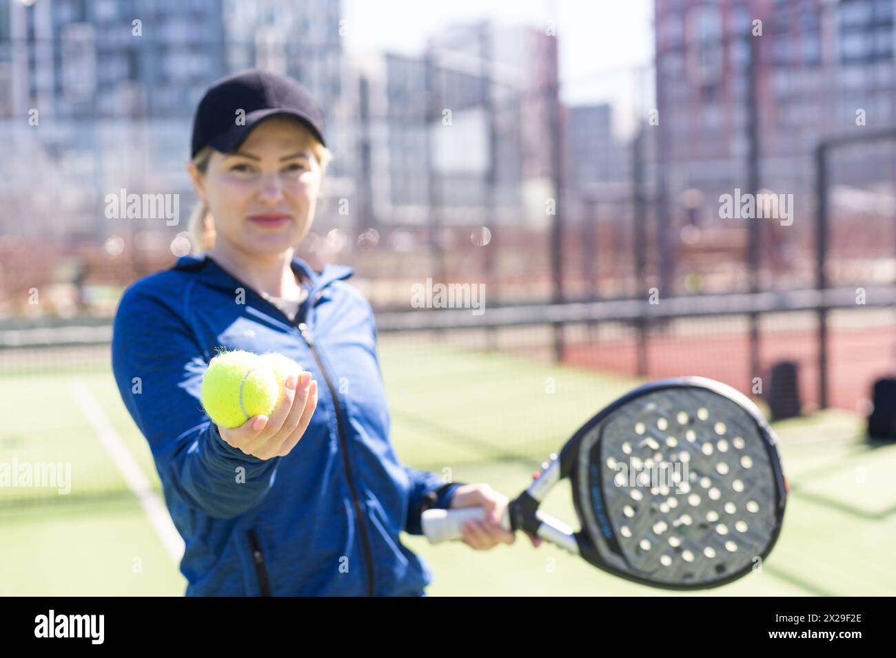 One woman with racquet and ball behind the net in paddle tennis court ...