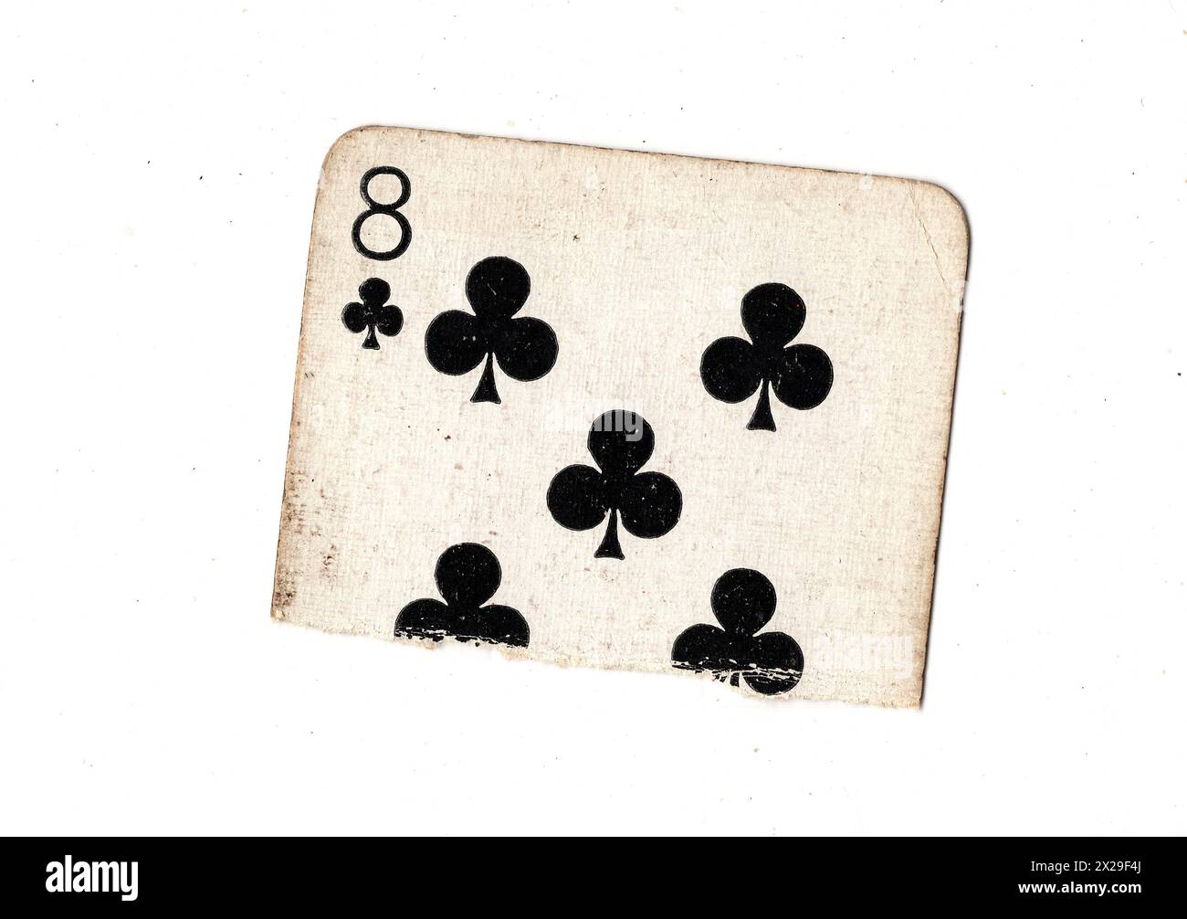 A torn half of a vintage, well used eight of clubs playing card ...