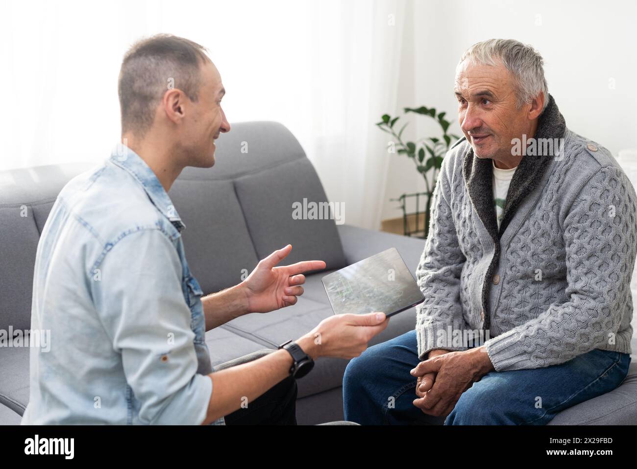 Elderly son takes care of ill father Stock Photo - Alamy