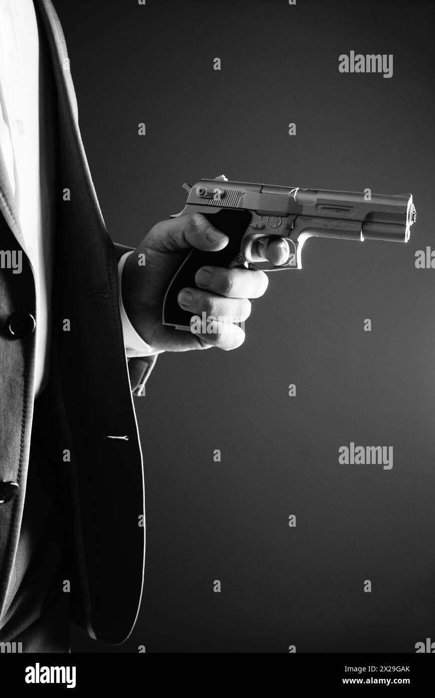 Retro secret agent with pistol revolver gun in hand in vintage crime ...