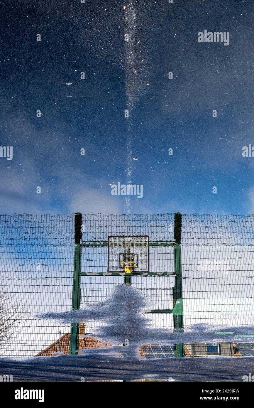 Basketball hoop reflecting in a puddle Stock Photo - Alamy