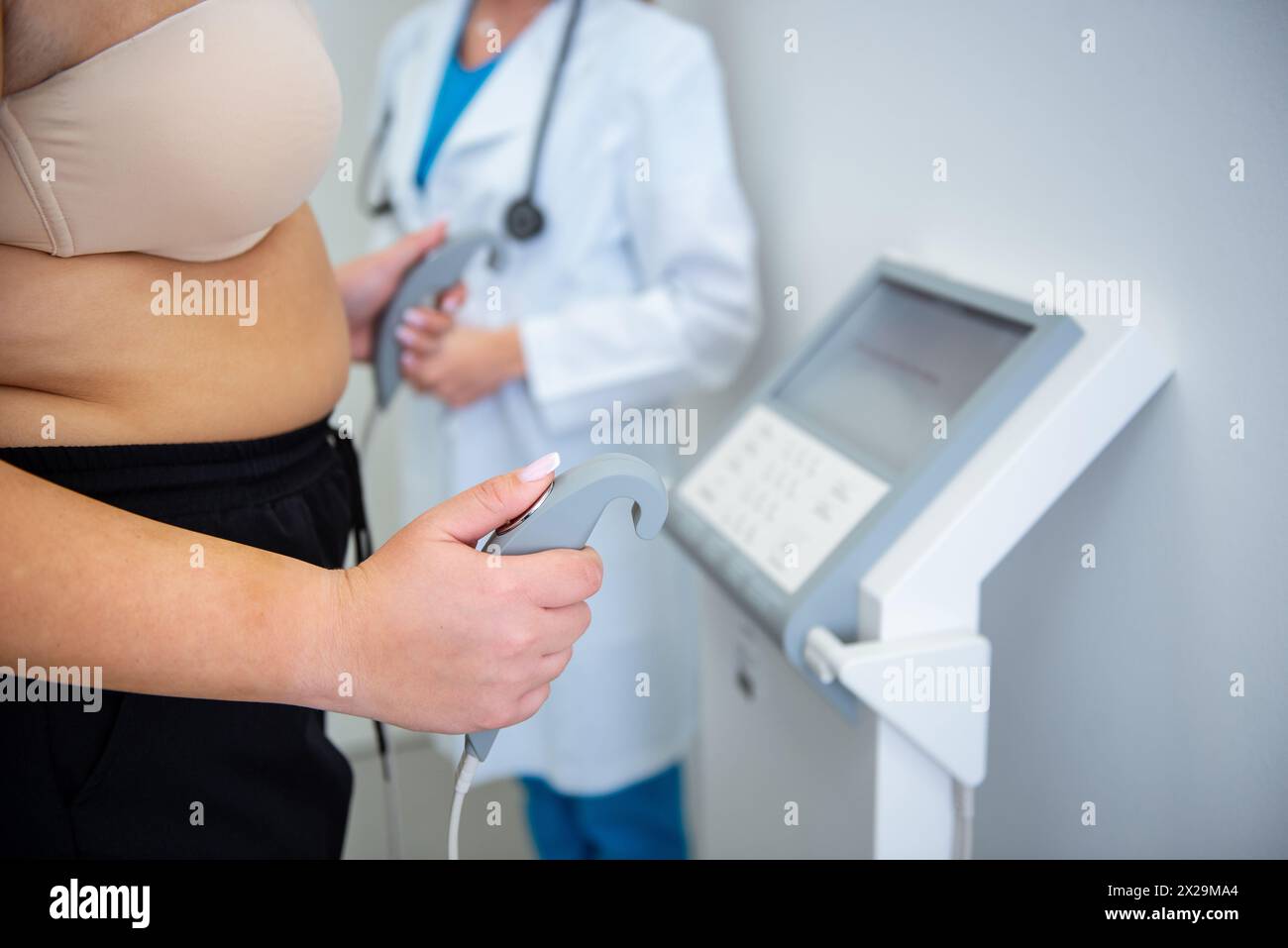 A health practitioner assists obese young woman with a body composition ...