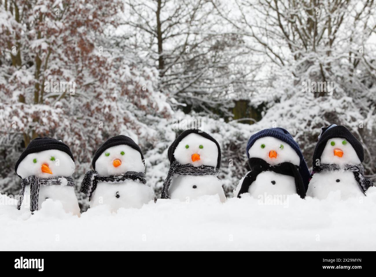 Little snowmen with winter clothes out in the deep snow at Christmas ...