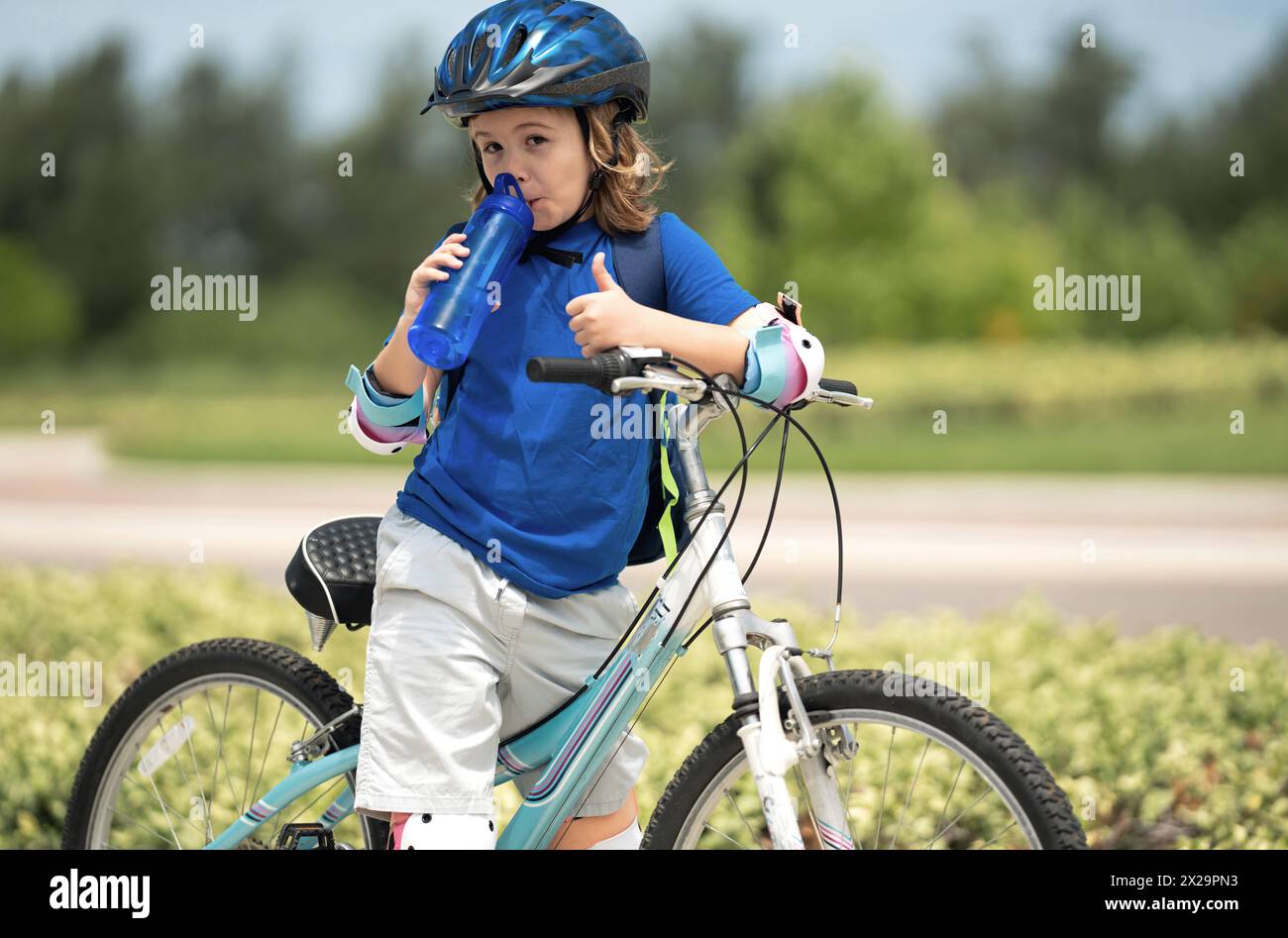 Little kid boy riding a bike in summer park. Child drive a bike on a ...