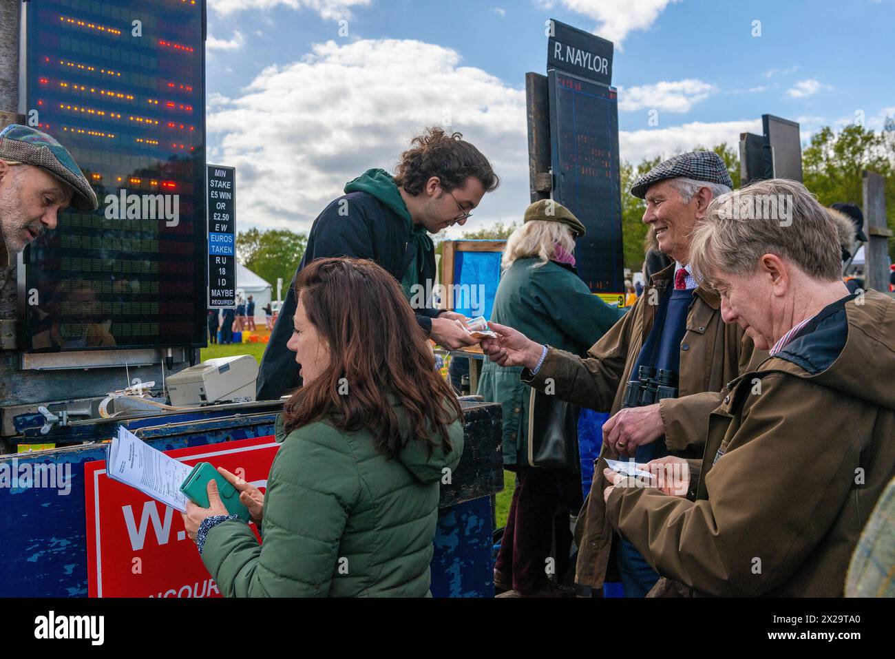 Crowds gather around the Bookmaker Stands in the field to place bets on ...