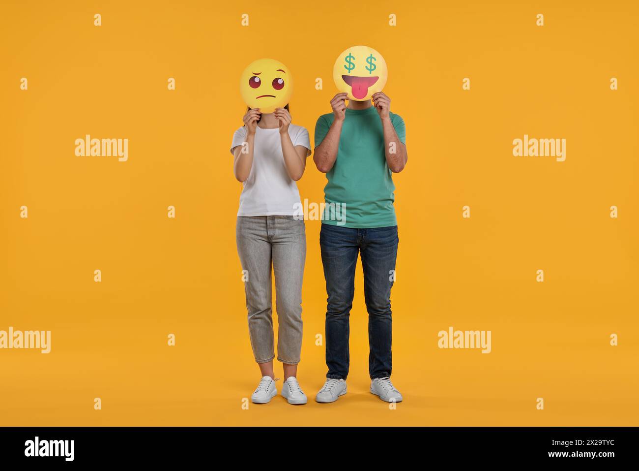 People covering faces with emoticons on yellow background Stock Photo ...