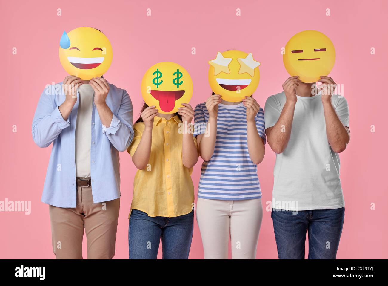 People covering faces with emoticons on pink background Stock Photo - Alamy