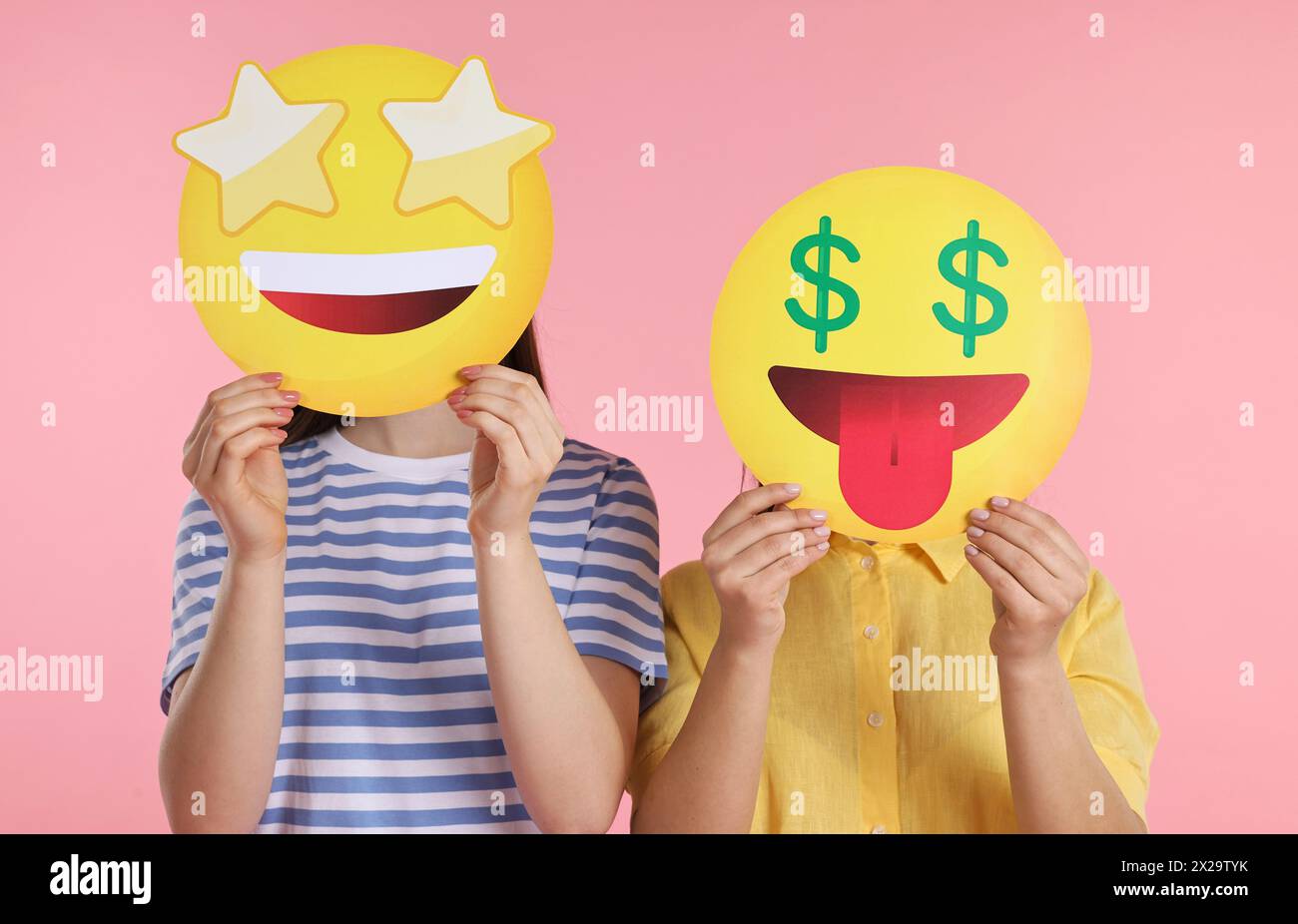 People covering faces with emoticons on pink background Stock Photo - Alamy