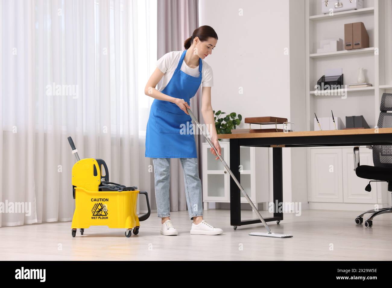 Cleaning service. Woman washing floor with mop in office Stock Photo ...