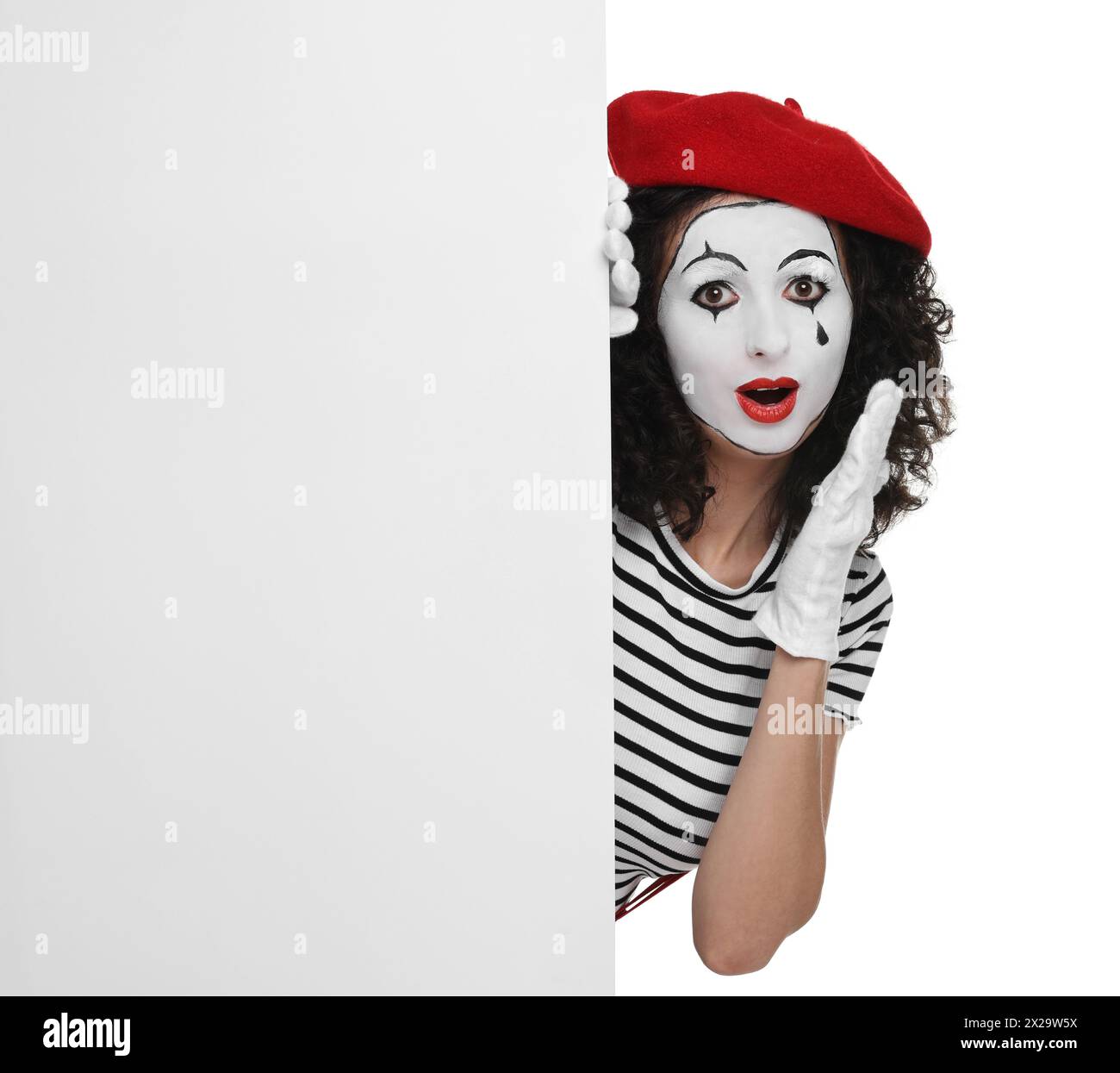 Funny mime with blank poster posing on white background Stock Photo - Alamy