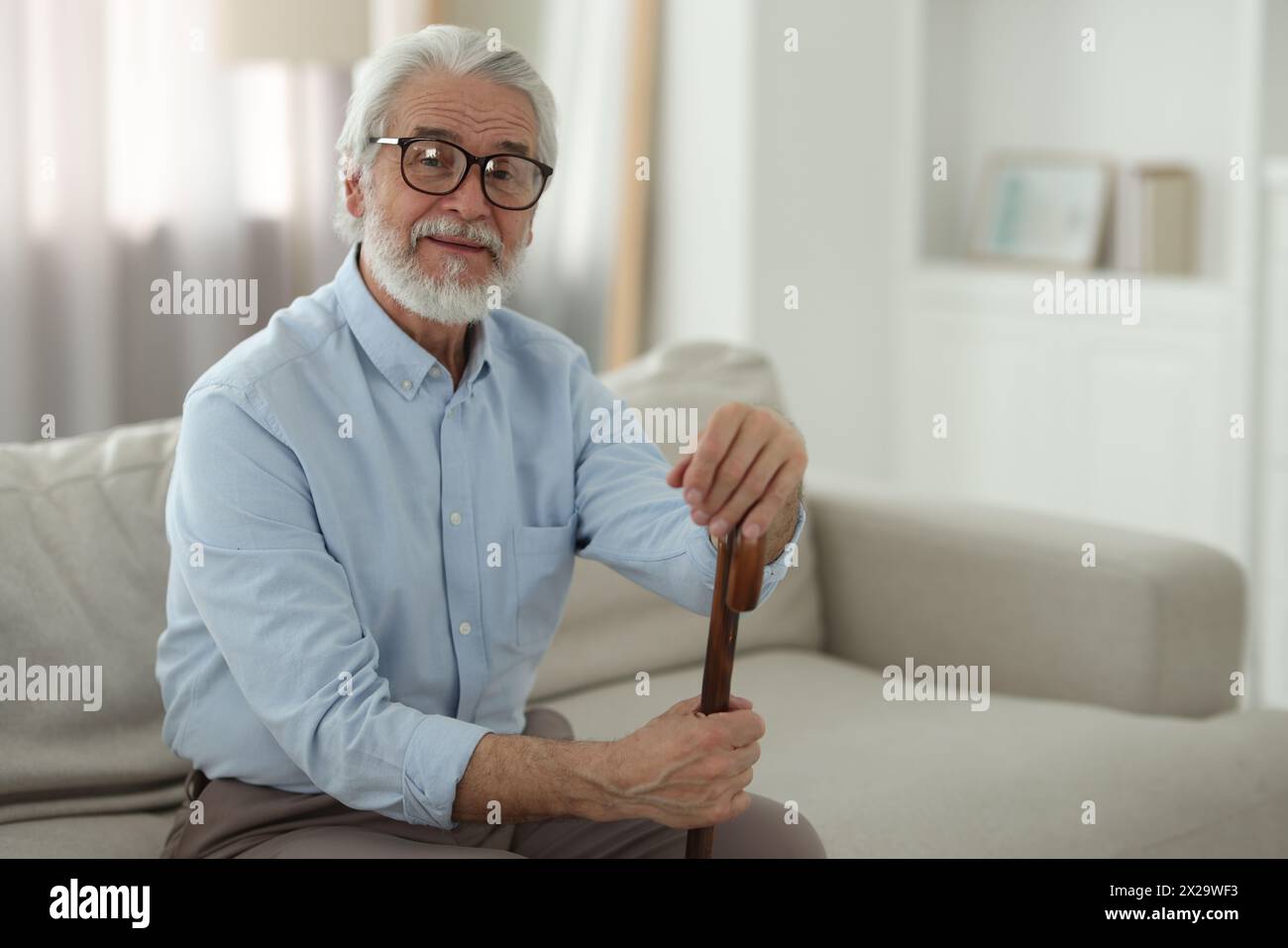Portrait of grandpa with glasses and walking cane on sofa indoors Stock ...