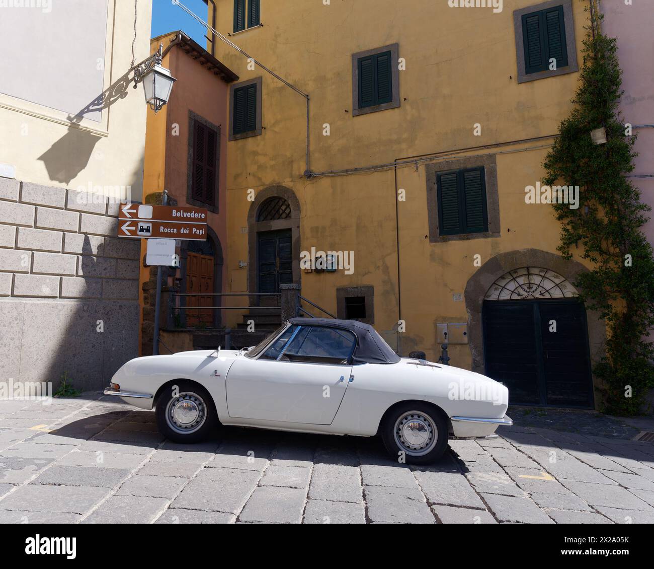 Classic Fiat 850 convertible car in white in a quaint square in ...