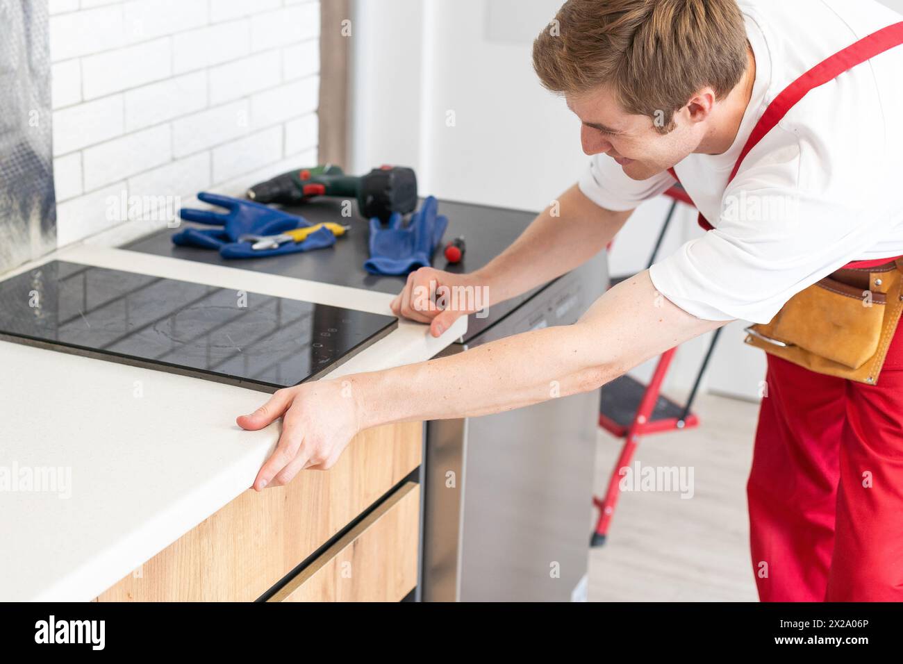 Young Repairman Installing Induction Cooker In Kitchen Stock Photo - Alamy