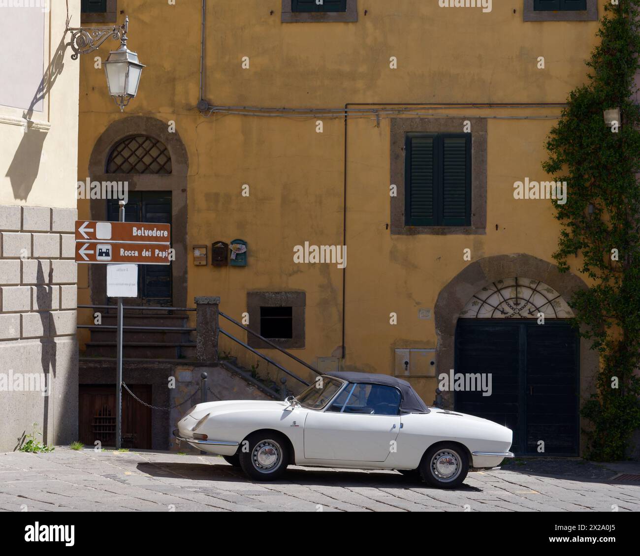 Classic Fiat 850 convertible car in white in a quaint square in ...