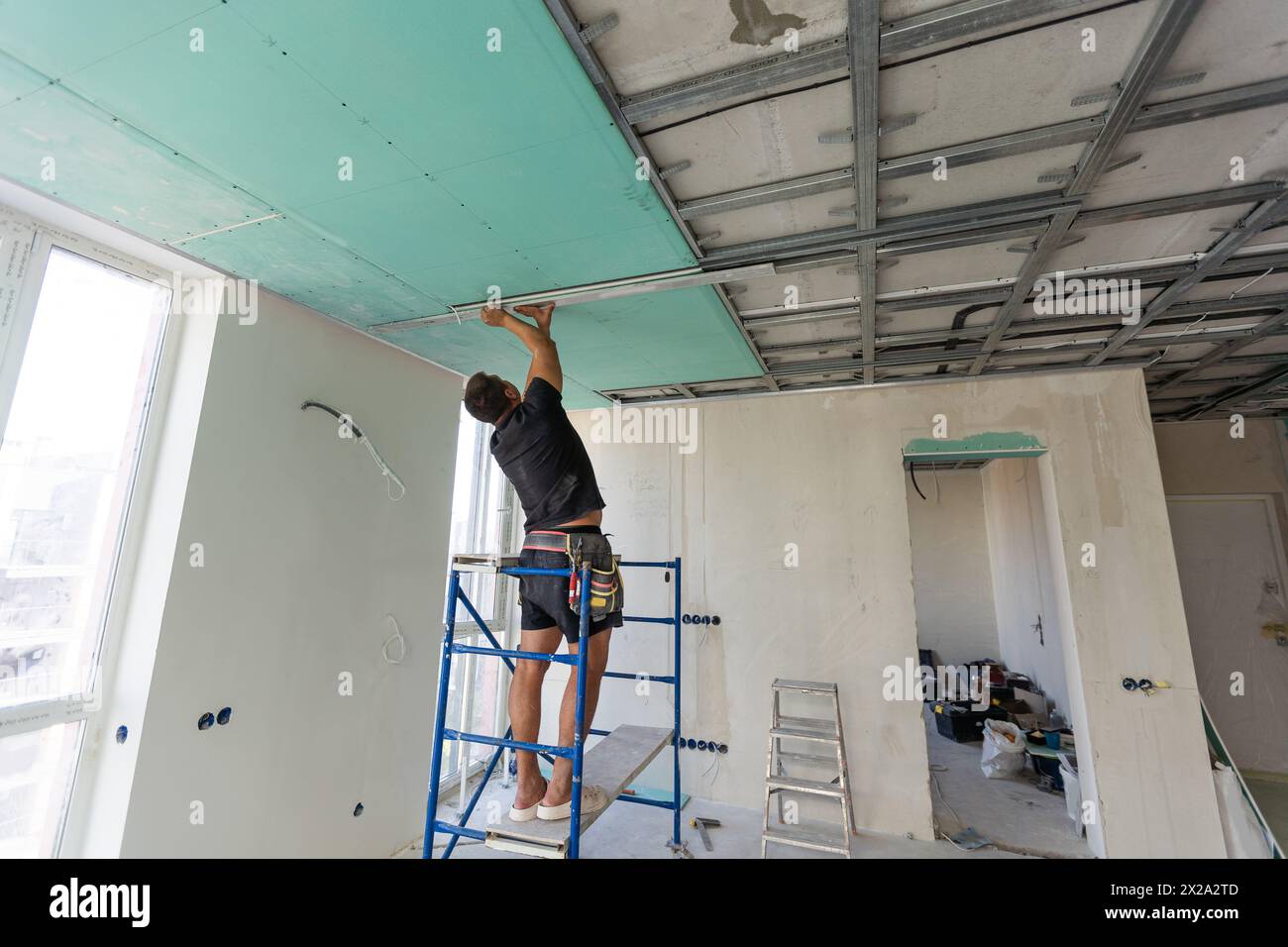 Two workers are mounted ceiling in the new flat Stock Photo - Alamy