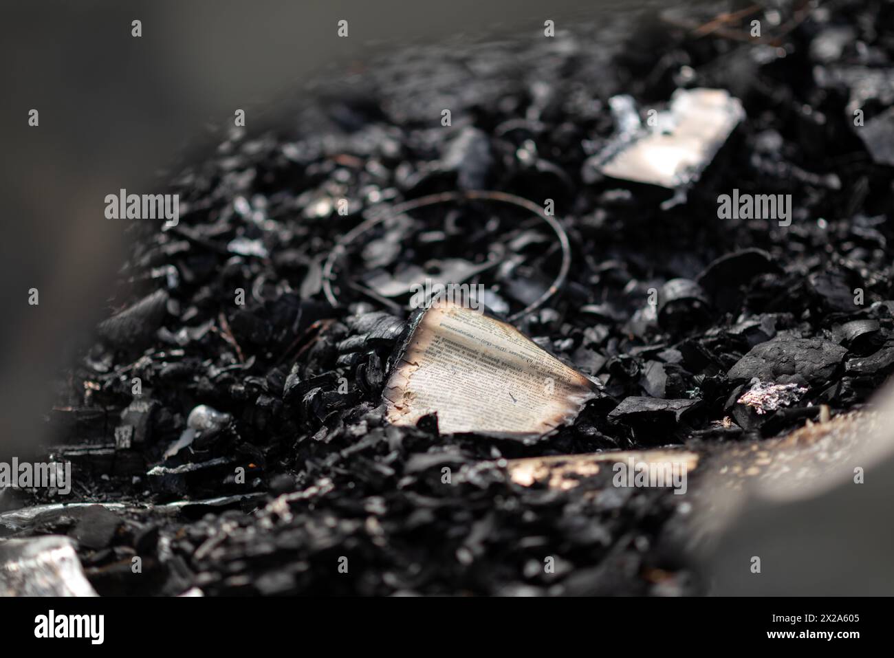 A burnt book on a pile of ashes, the remains of pages in a burnt house ...