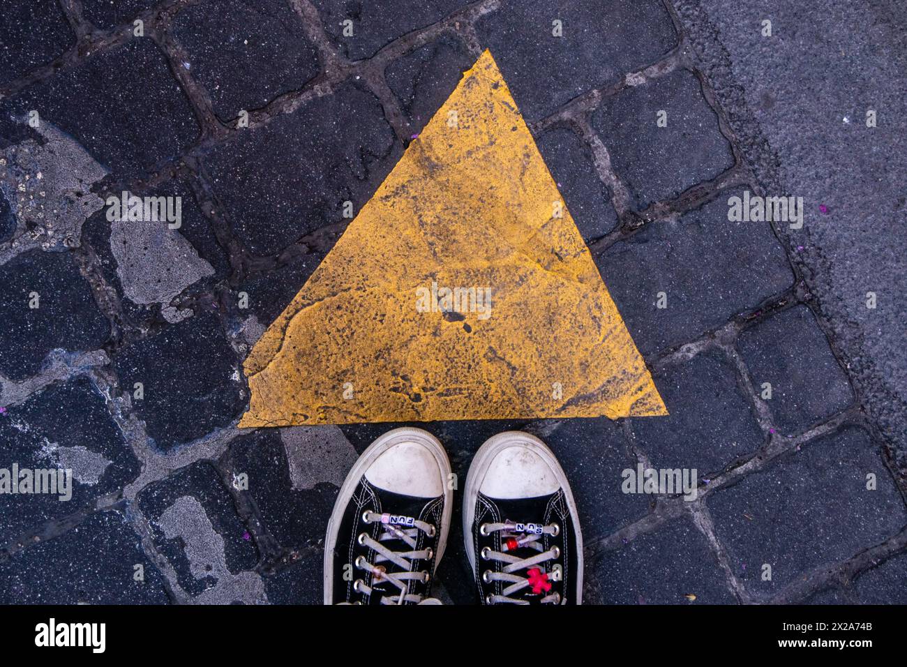 Yellow pointing arrow on stone road top view and women's feet shoeing ...
