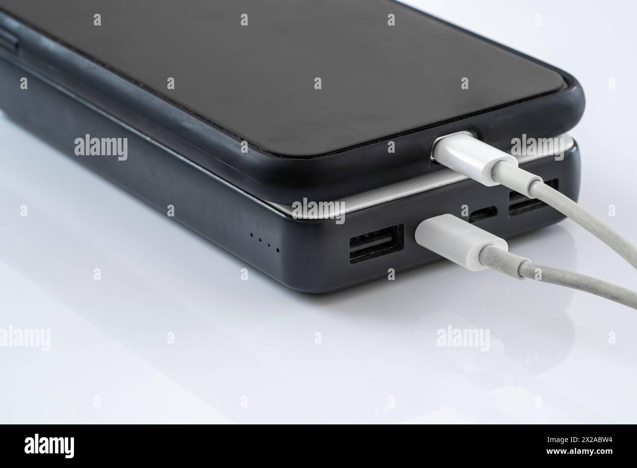 A mobile phone connected to an external battery with a usb cable for ...