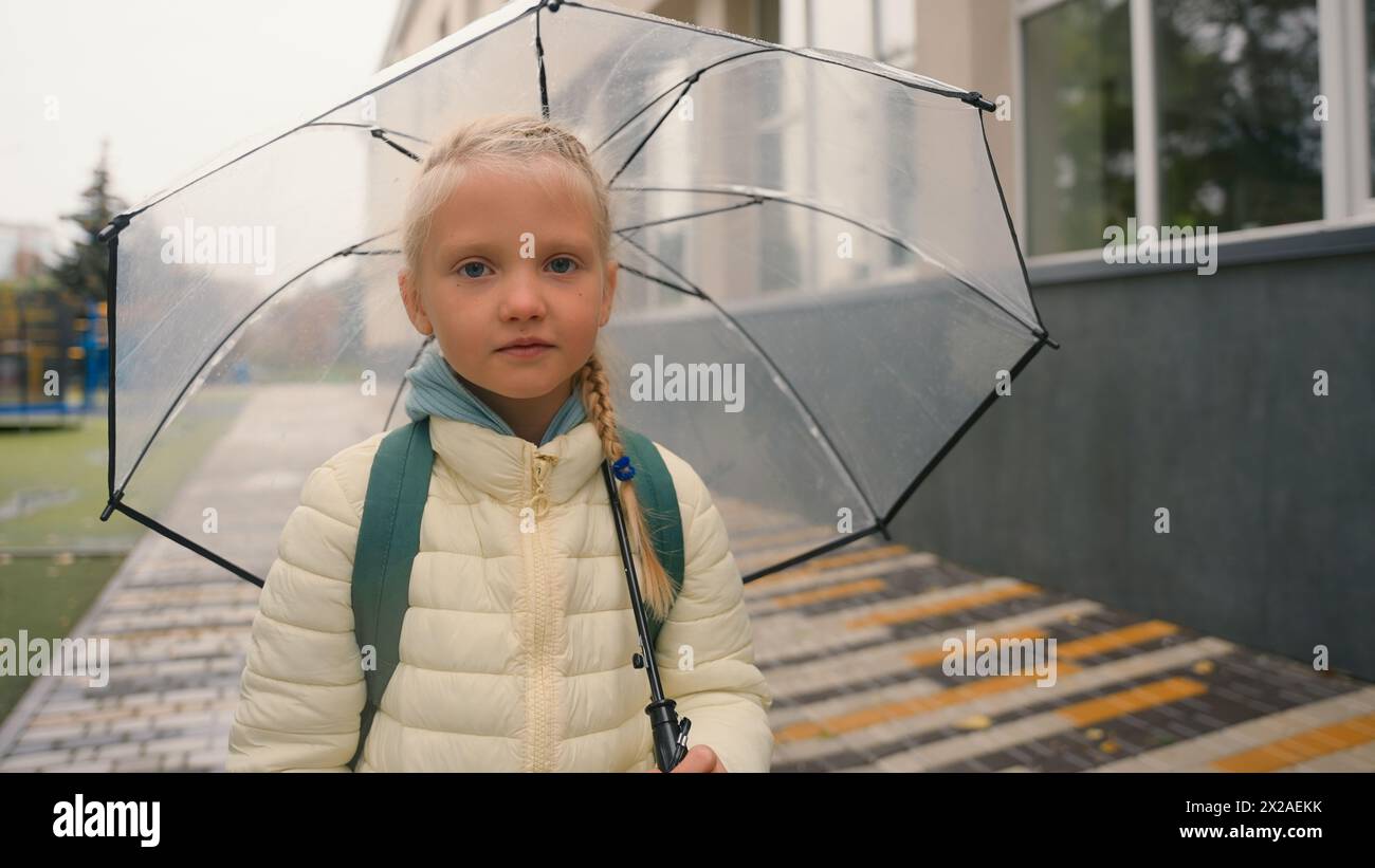 Schoolgirl little girl going holding umbrella rain weather damp cloudy ...