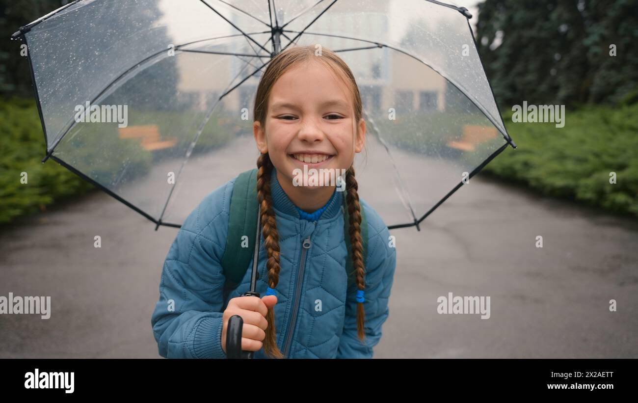 Cheerful little girl looking at camera show tongue grimace face ...
