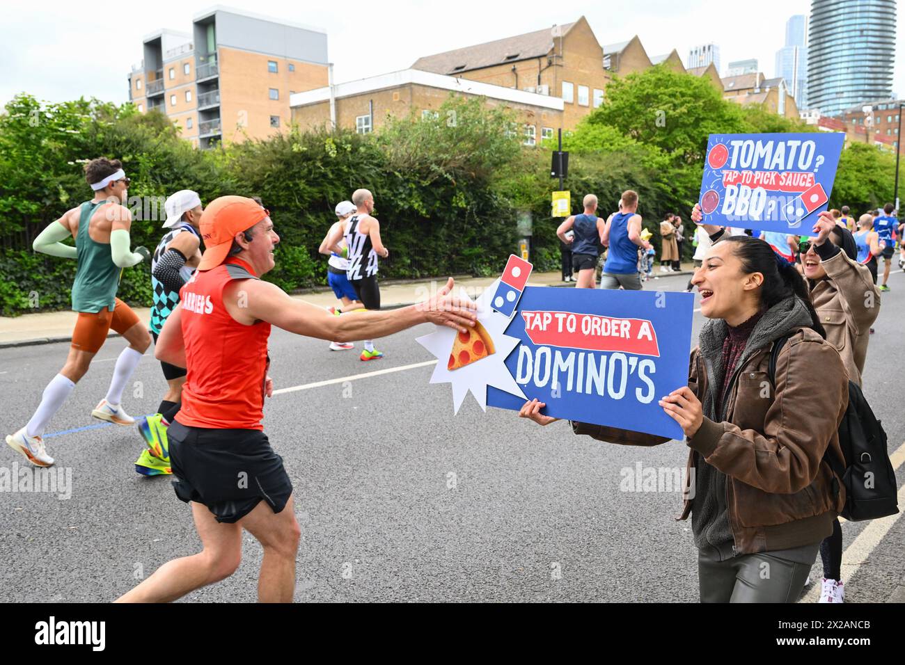 EDITORIAL USE ONLY A runner taps a sign to order their Domino's pizza ...