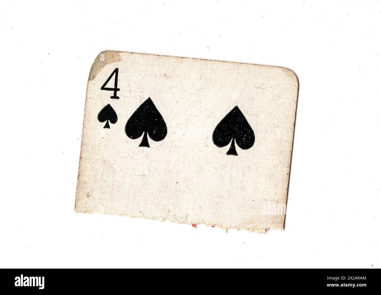 A torn half of a vintage, well used four of spades playing card ...
