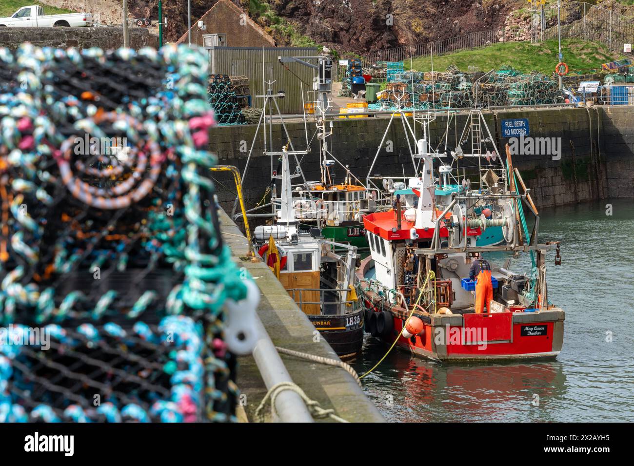 Harbour view with fishing boats and lobster pots in the Scottish ...