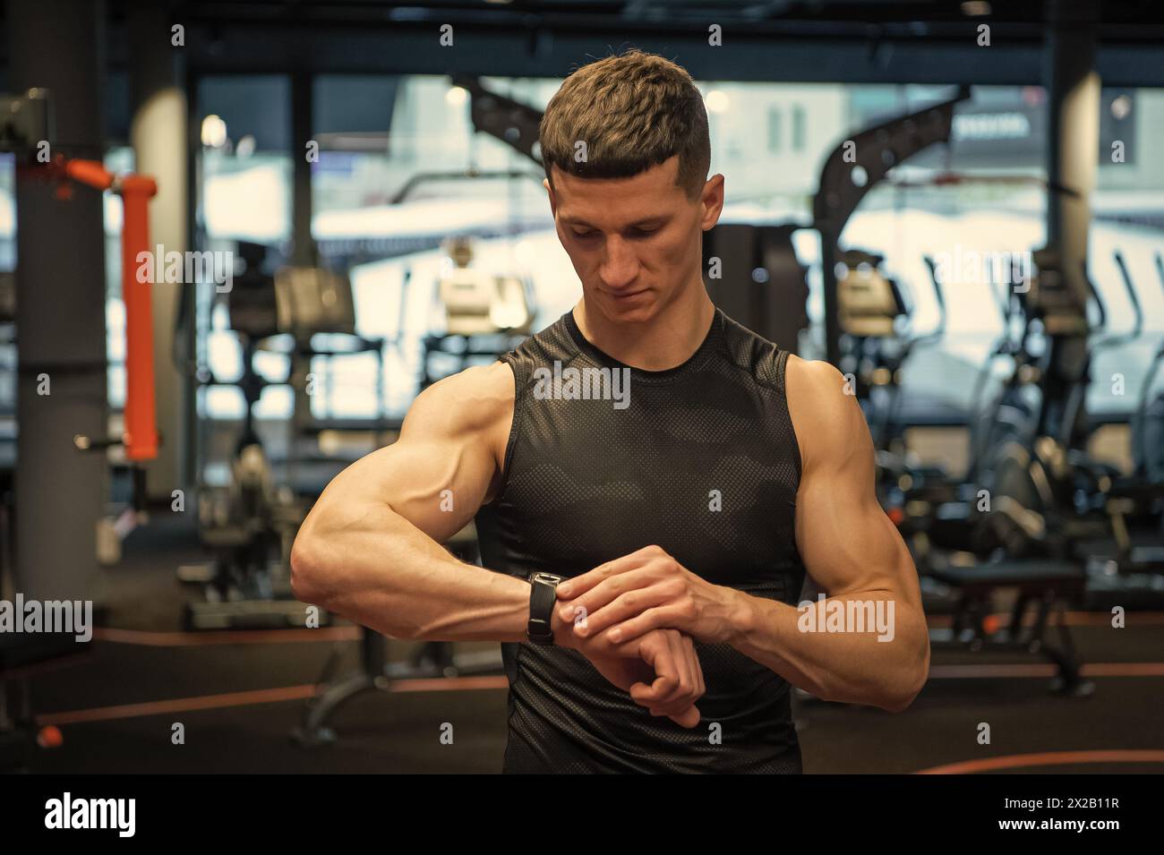 fit athlete monitoring physical activity by smartwatch in gym. fit ...