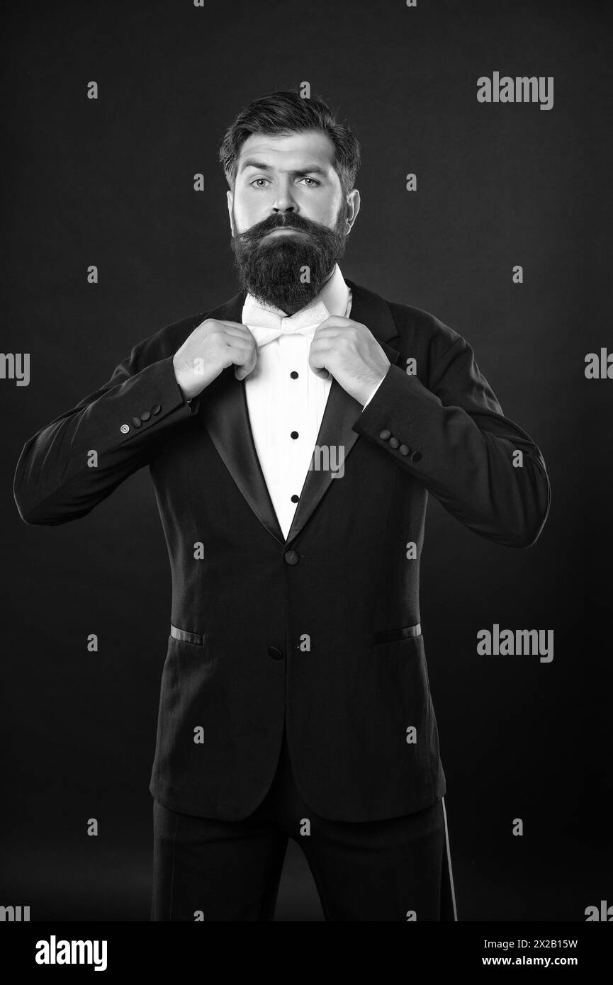 elegant butler in tuxedo on black background, bow tie Stock Photo - Alamy