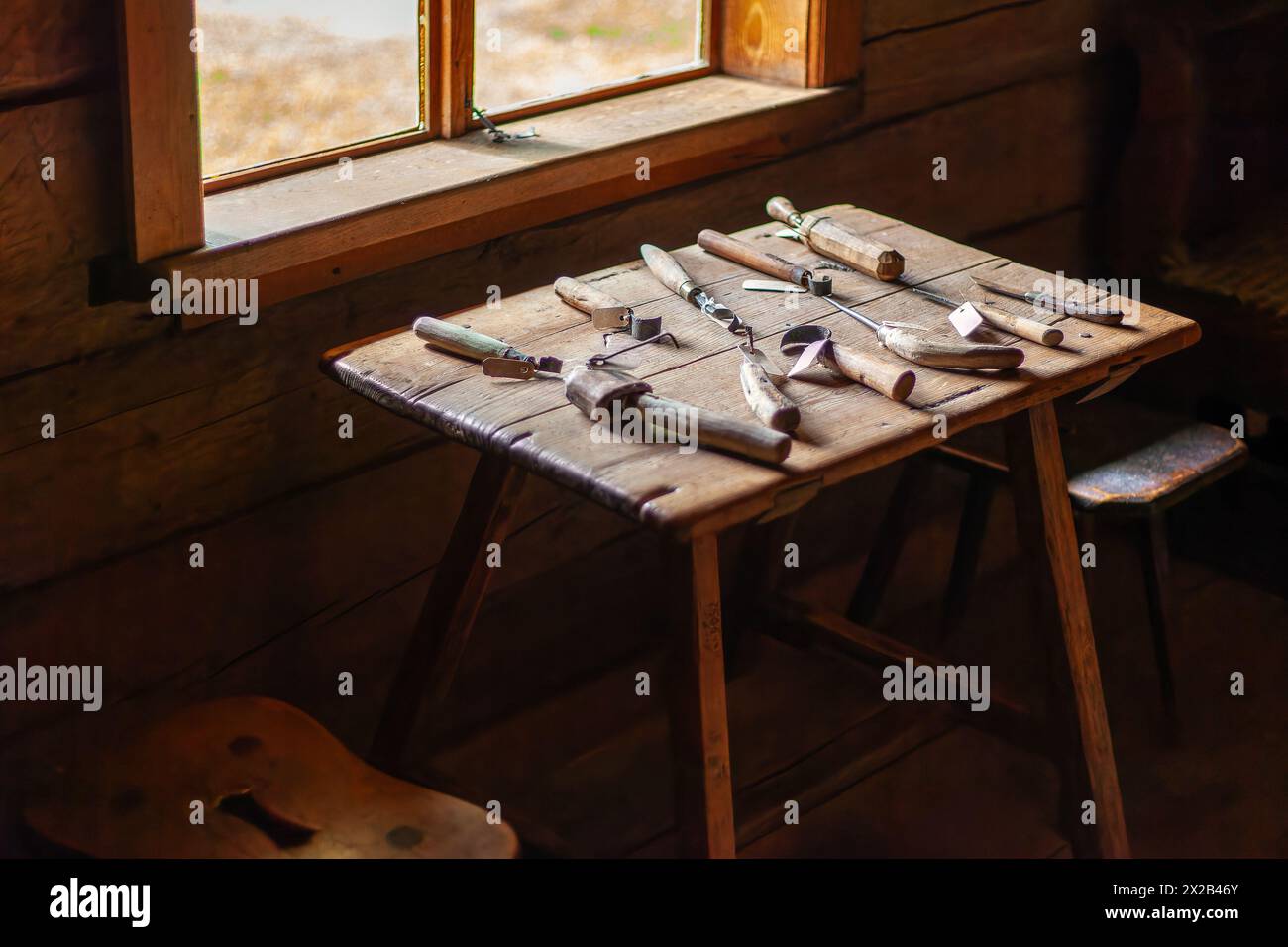 Antique clog carving tools on the table by the window. Horizontal photo ...