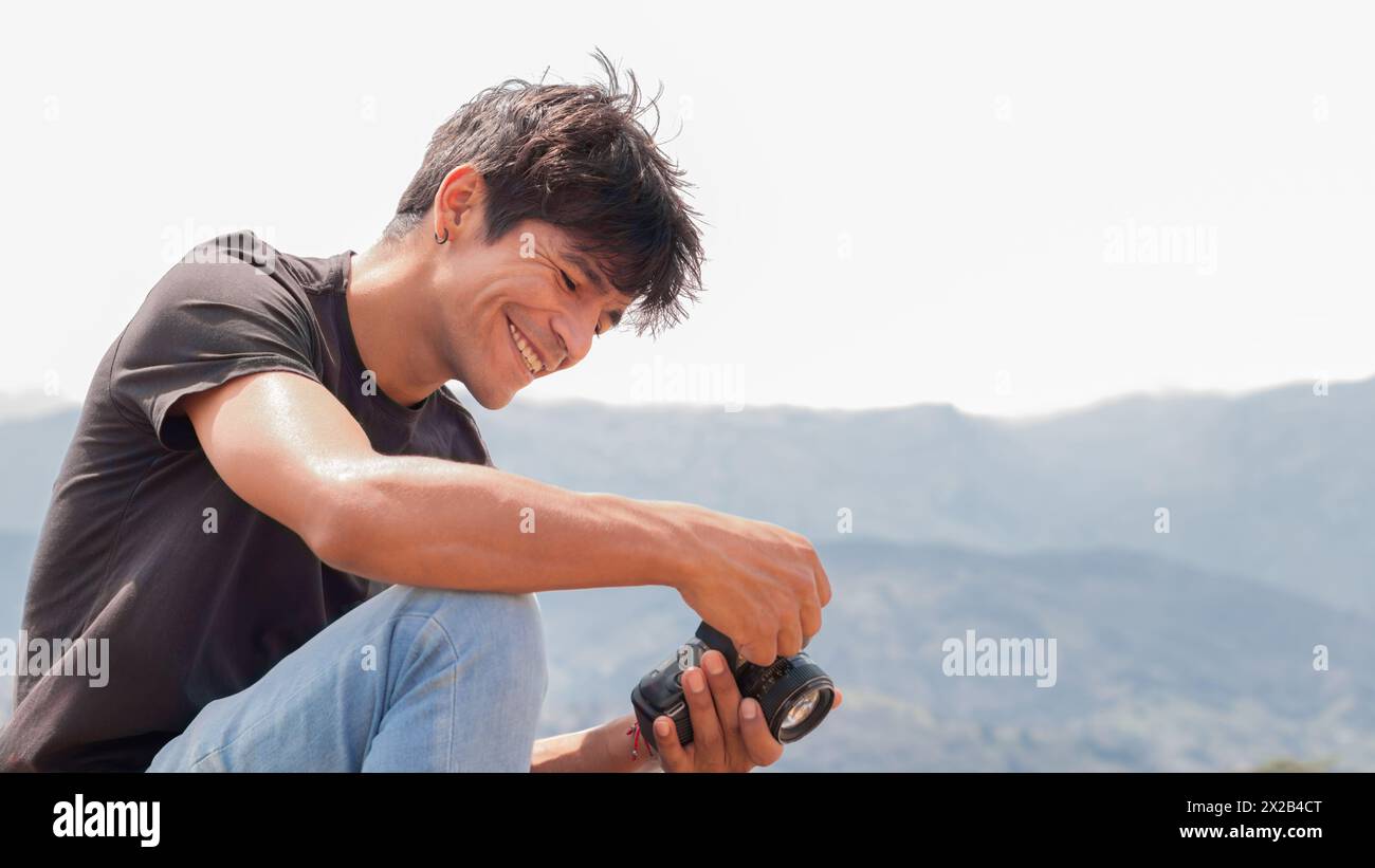 lifestyle concept. Young latin man using camera and being very happy ...