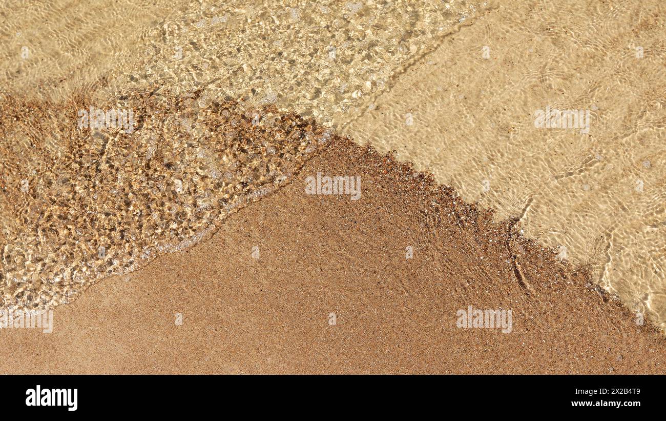 Diagonal lines of crystal sea water on clean sand of beach. Close up ...